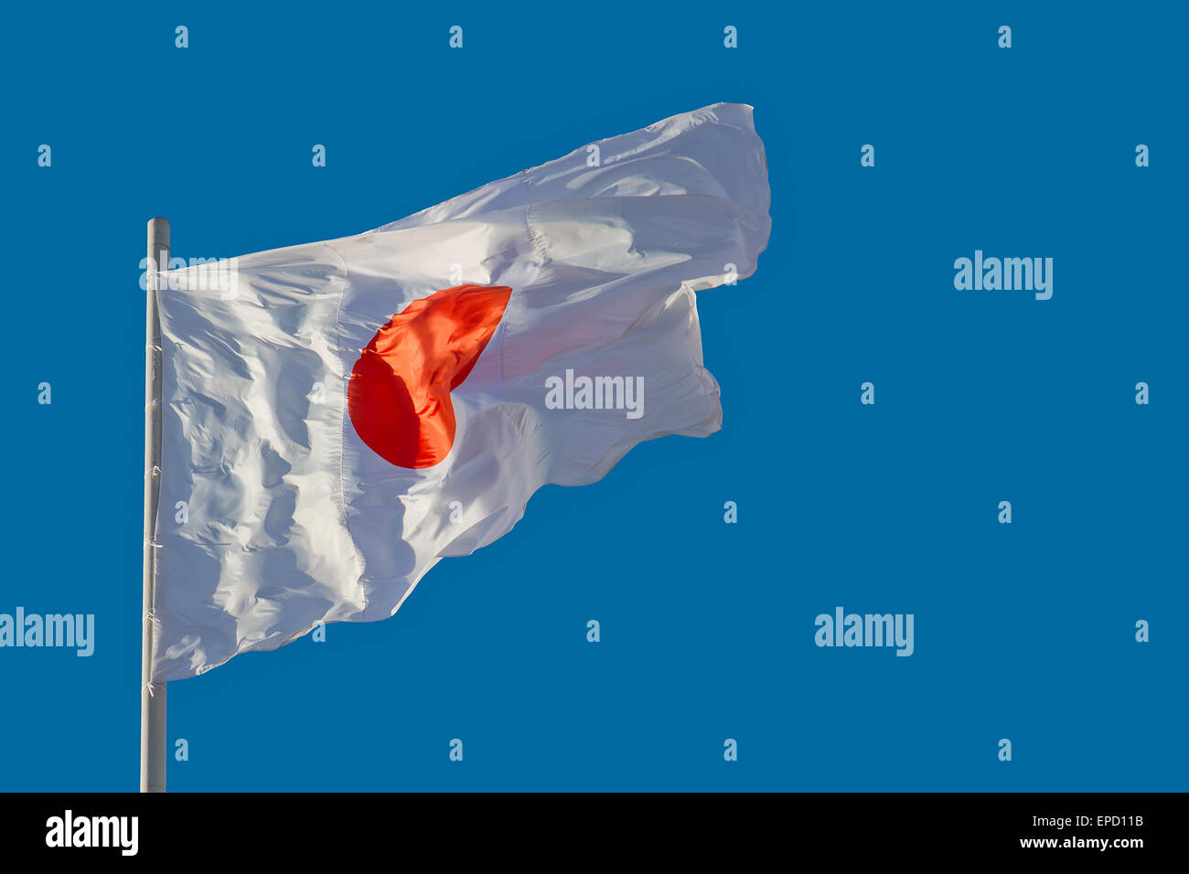 Japan flag is waving in front of blue sky Stock Photo - Alamy