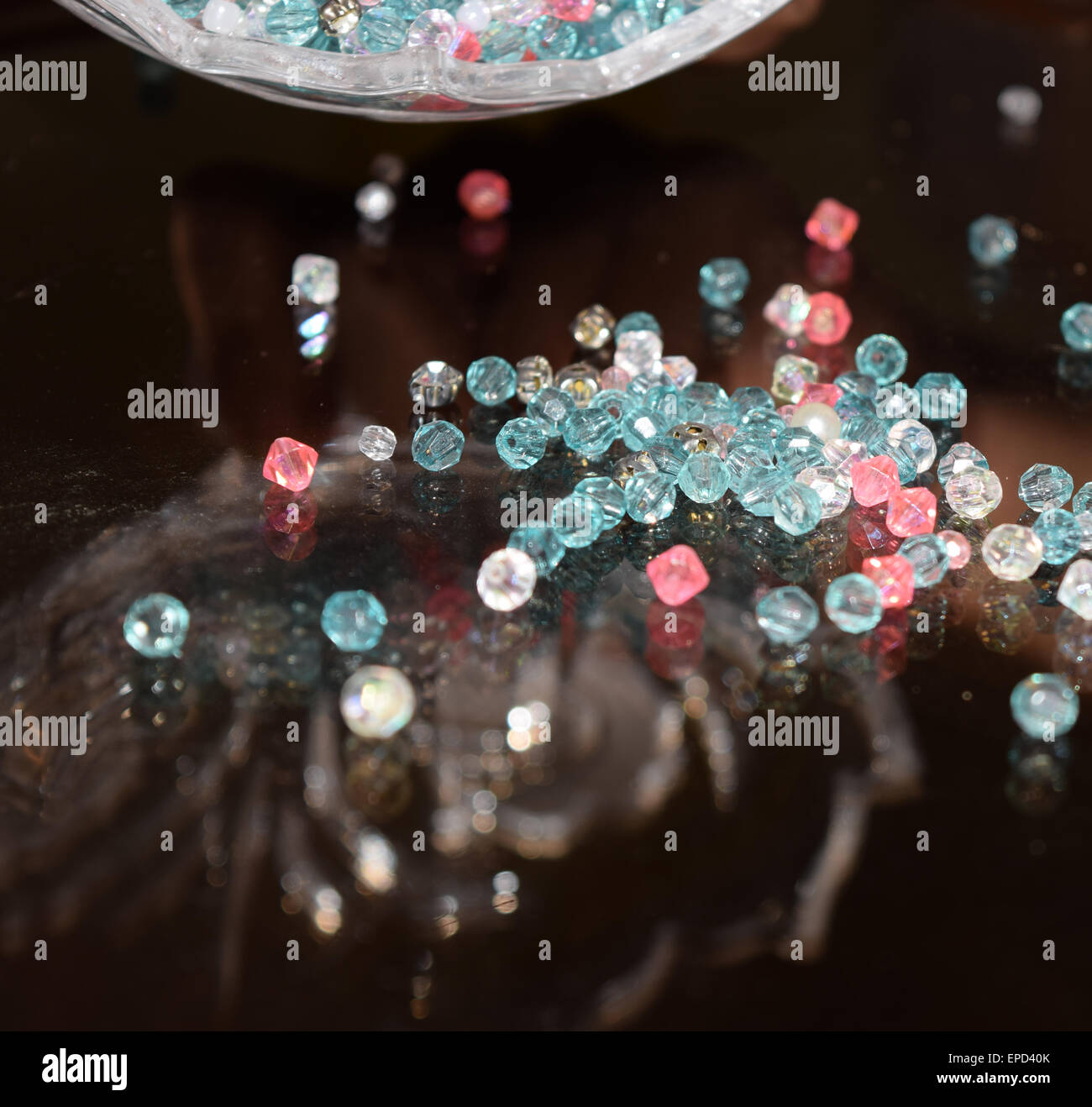 Colorful beads falling from a bowl reflecting on brown glass Stock ...