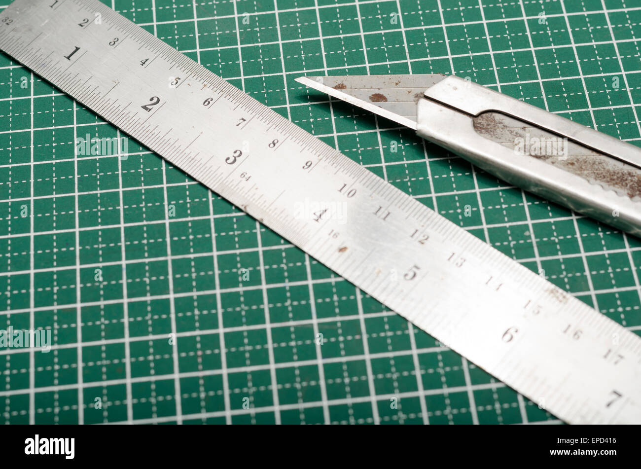 ruler and cutter on green cutting mat Stock Photo - Alamy