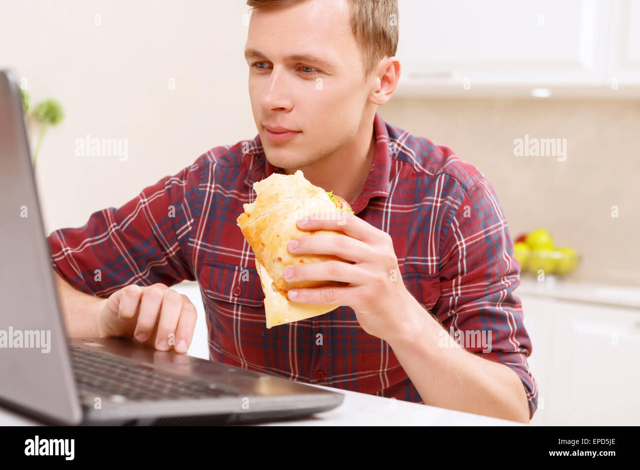 Man eating sandwich in front of computer Stock Photo - Alamy