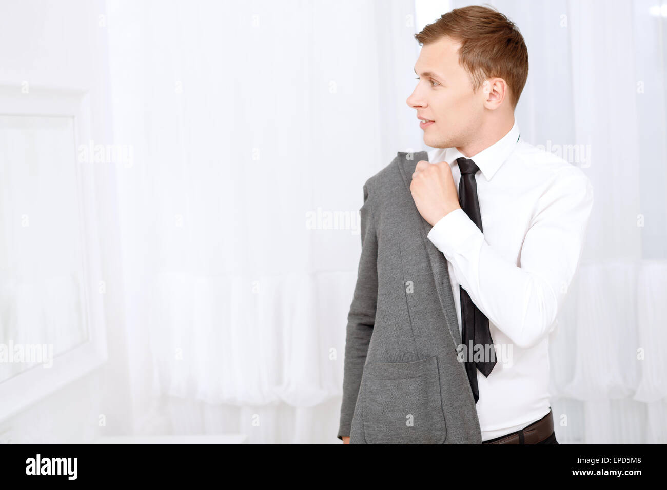 Young man holding jacket on his shoulder Stock Photo - Alamy