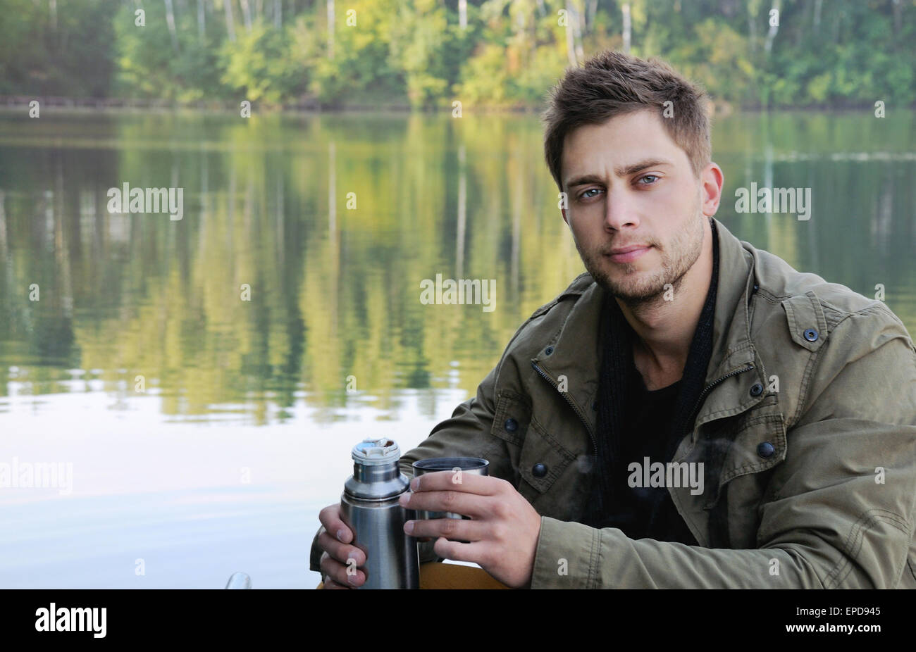 handsome attractive man at the lake on beautiful nature background ...