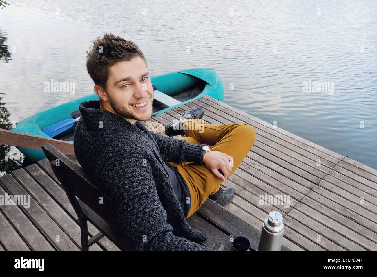 handsome attractive man on the wooden pier at the lake on beautiful ...