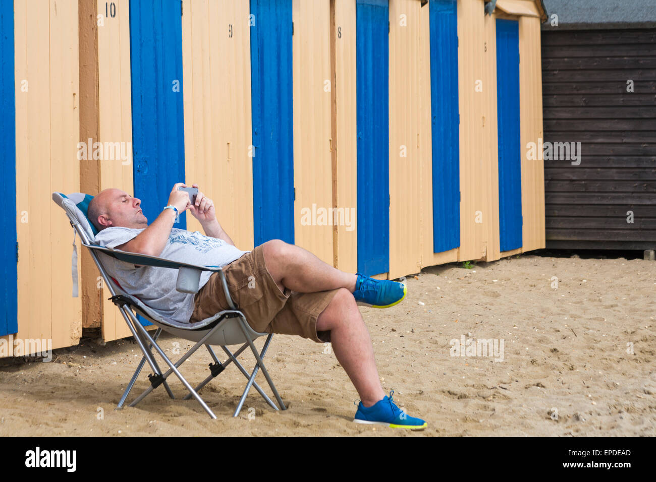 Man sitting in chair with iphone hi-res stock photography and images ...