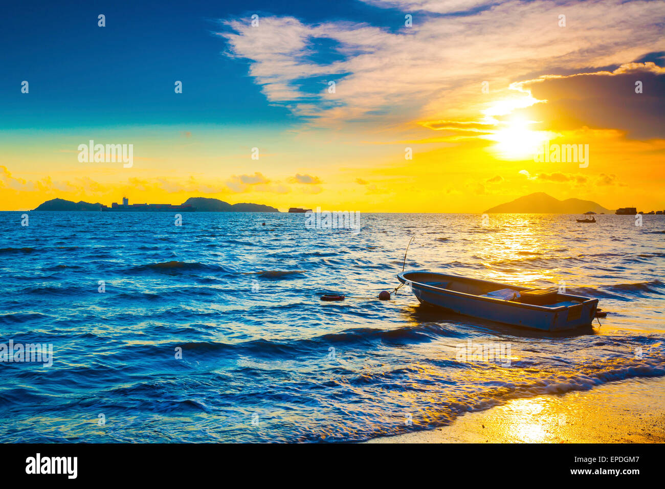 Boat on a sea coast at sunset Stock Photo - Alamy