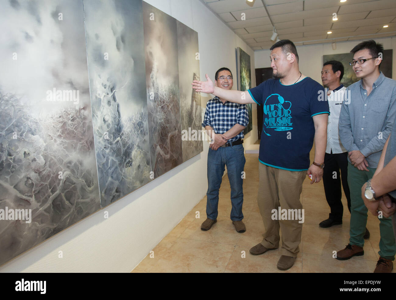 Beijing, China. 17th May, 2015. Painter Zhang Yucong (2nd L) introduces his artworks to audience ...