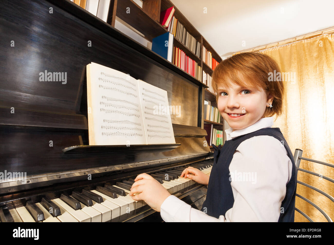 Smiling girl in school uniform playing the piano Stock Photo - Alamy