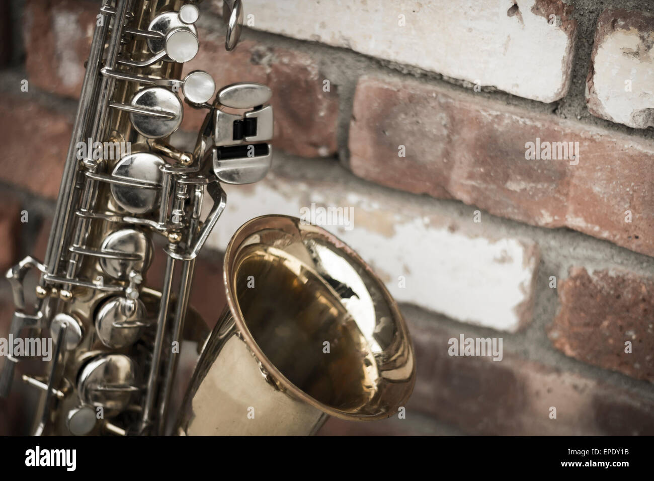 Lone old saxophone leans against brick wall outside abandoned jazz club ...
