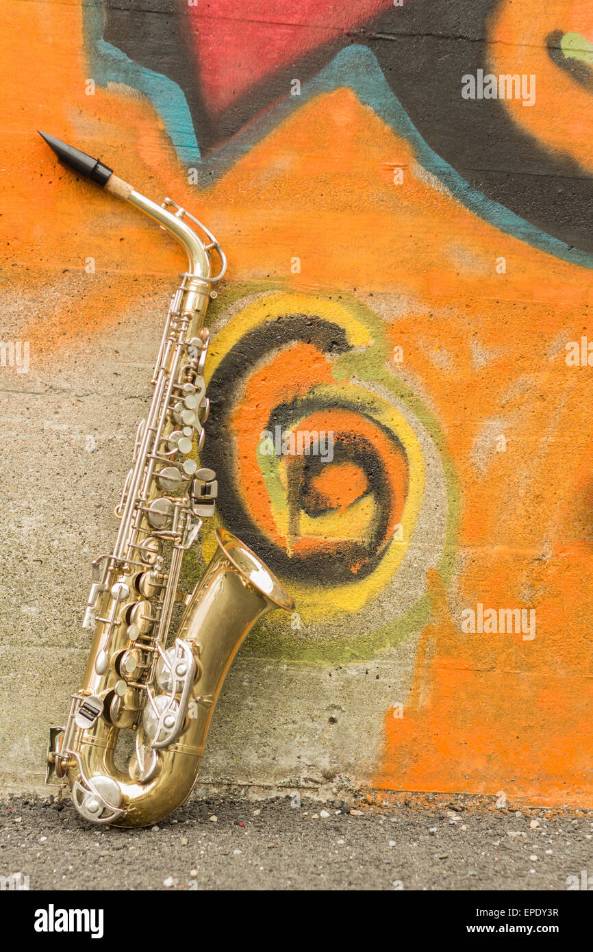 Lone old saxophone leans against brick wall outside abandoned jazz club ...