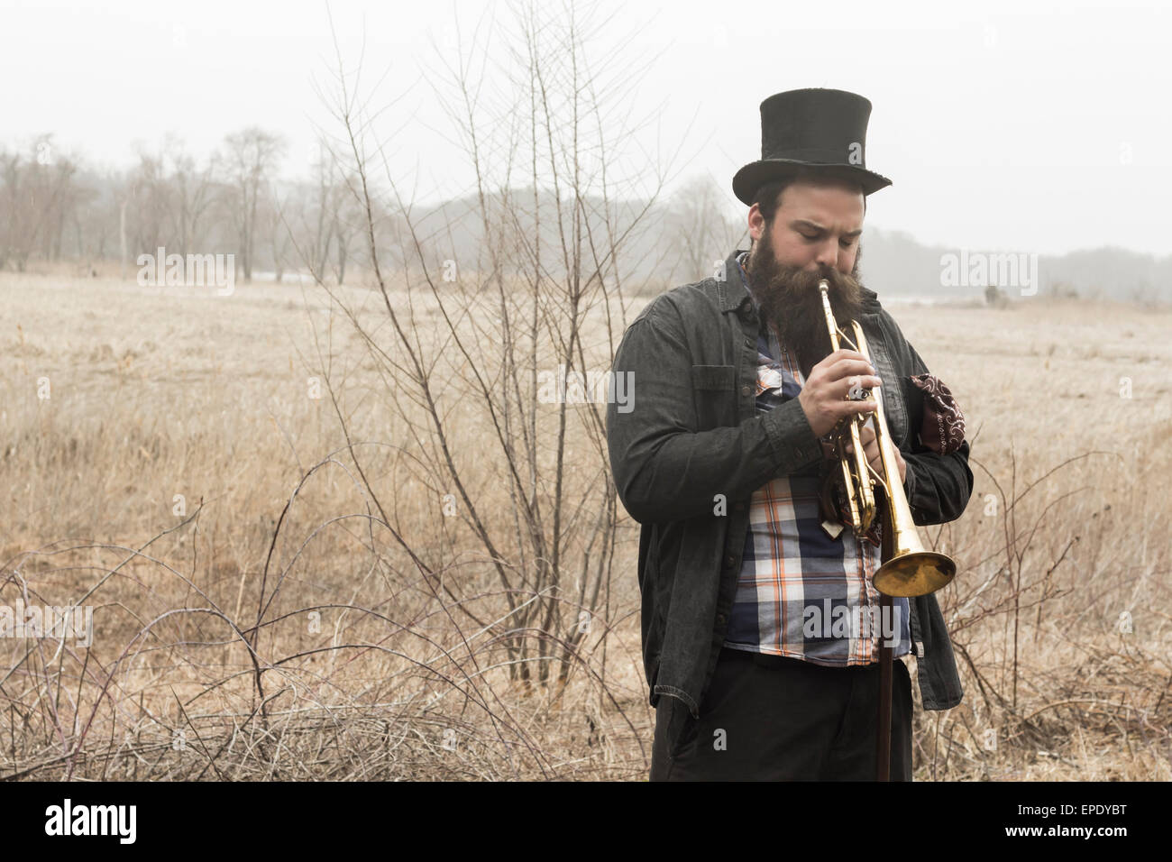 Stylish bearded gypsy plays trumpet on a wilderness path Stock Photo ...