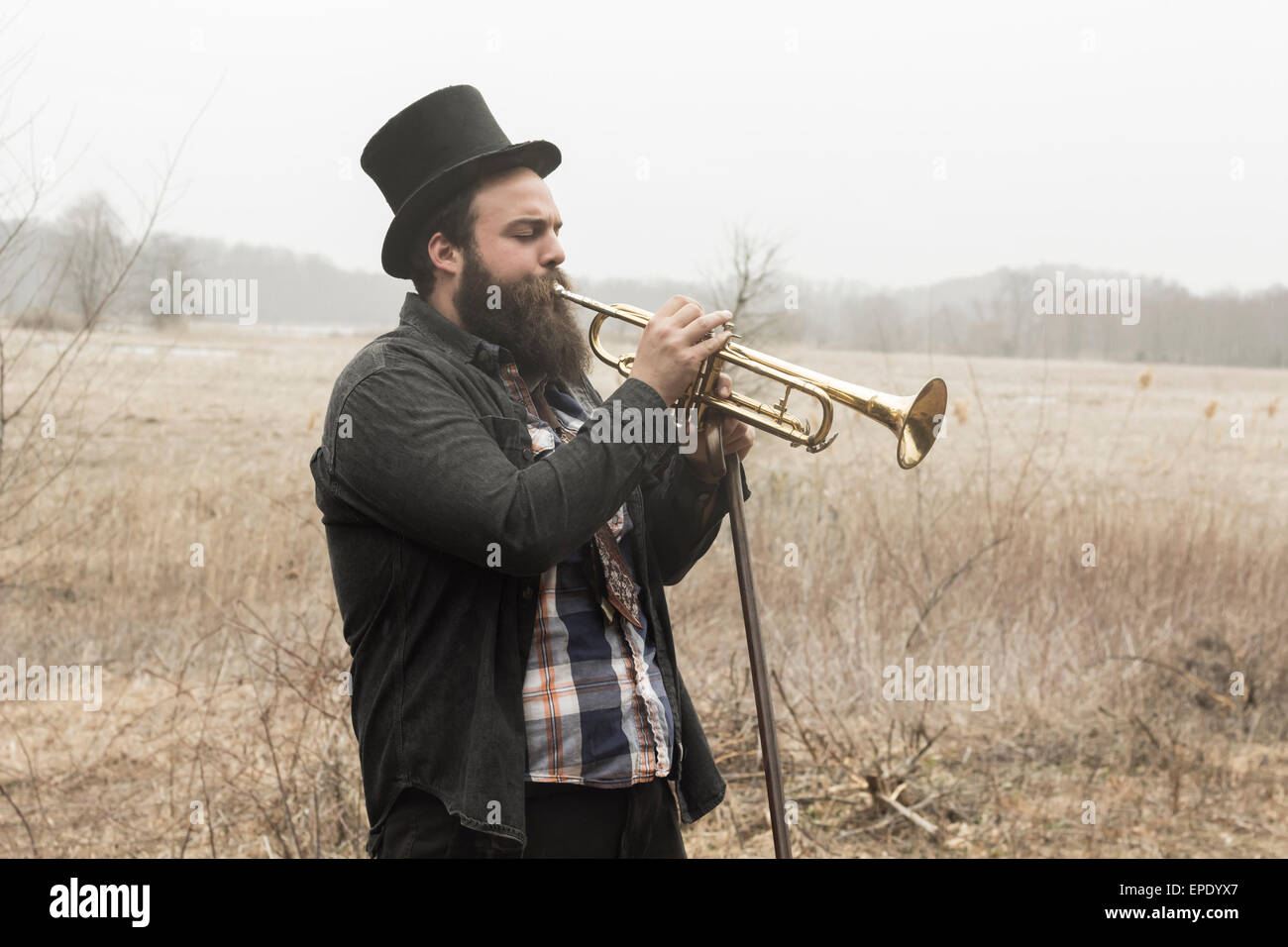 Stylish bearded gypsy plays trumpet on a wilderness path Stock Photo ...