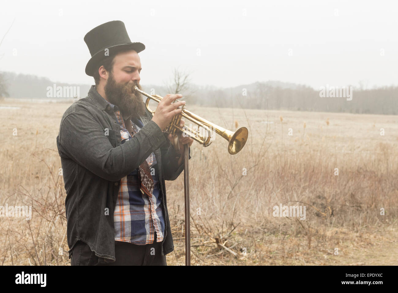 Stylish bearded gypsy plays trumpet on a wilderness path Stock Photo ...