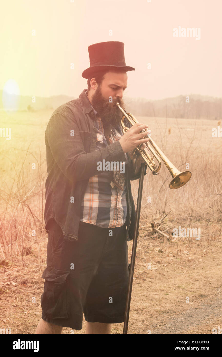 Stylish bearded gypsy plays trumpet on a wilderness path Stock Photo ...