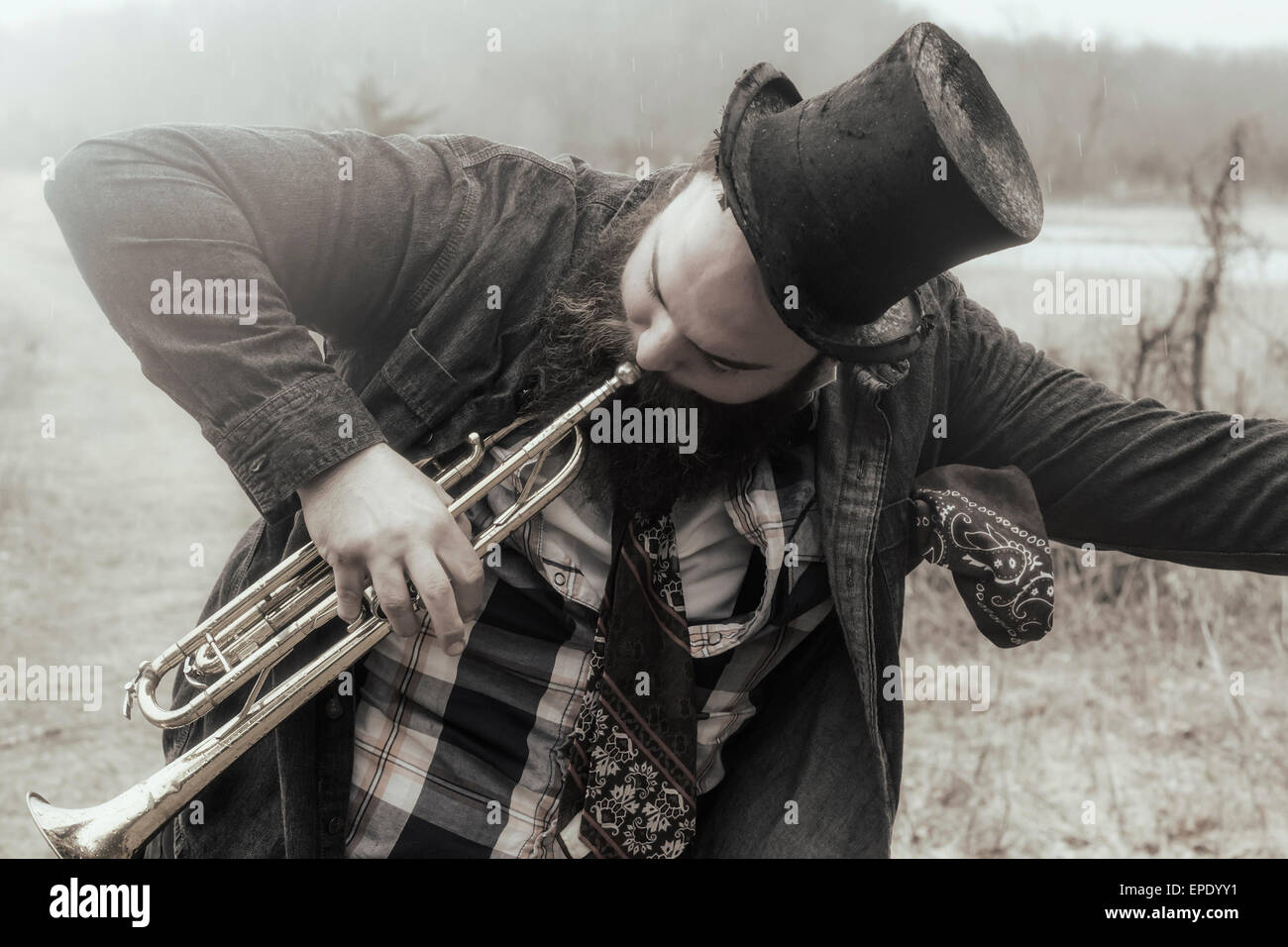 Stylish bearded gypsy plays trumpet on a wilderness path Stock Photo ...