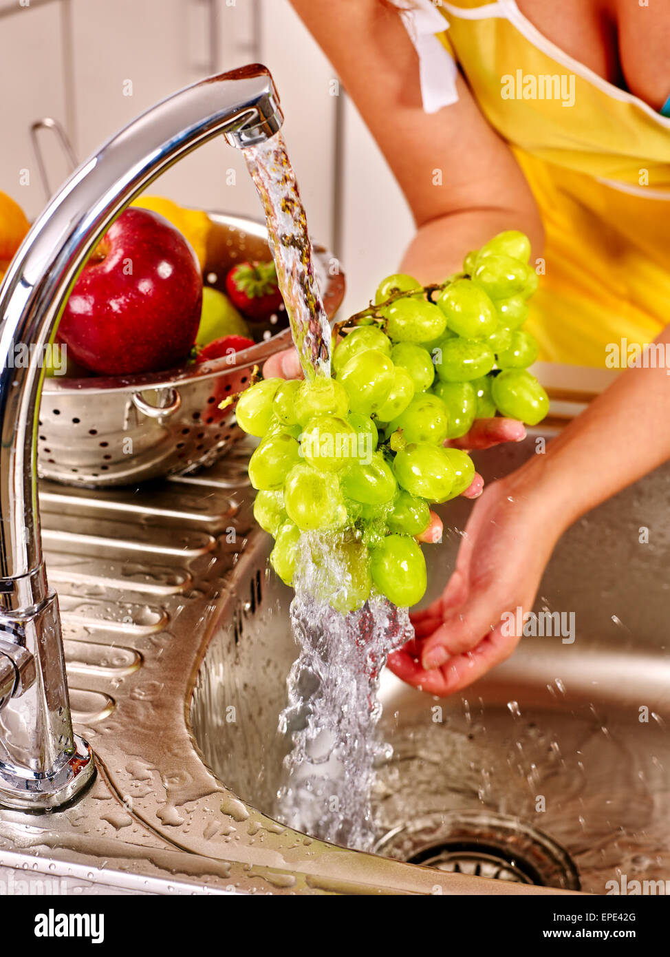 Woman washing fruit at kitchen Stock Photo - Alamy