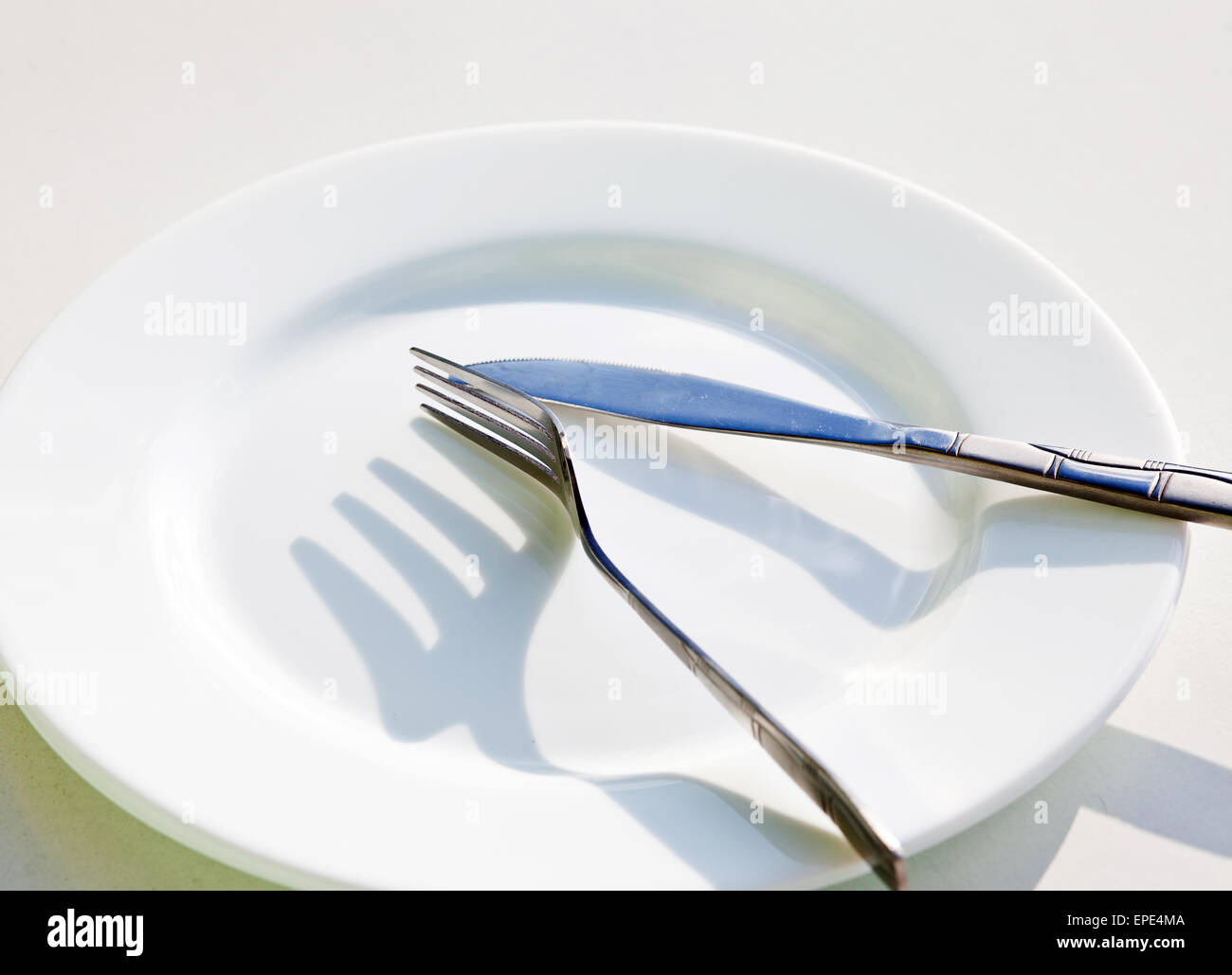 Knife, white plate and fork Stock Photo - Alamy