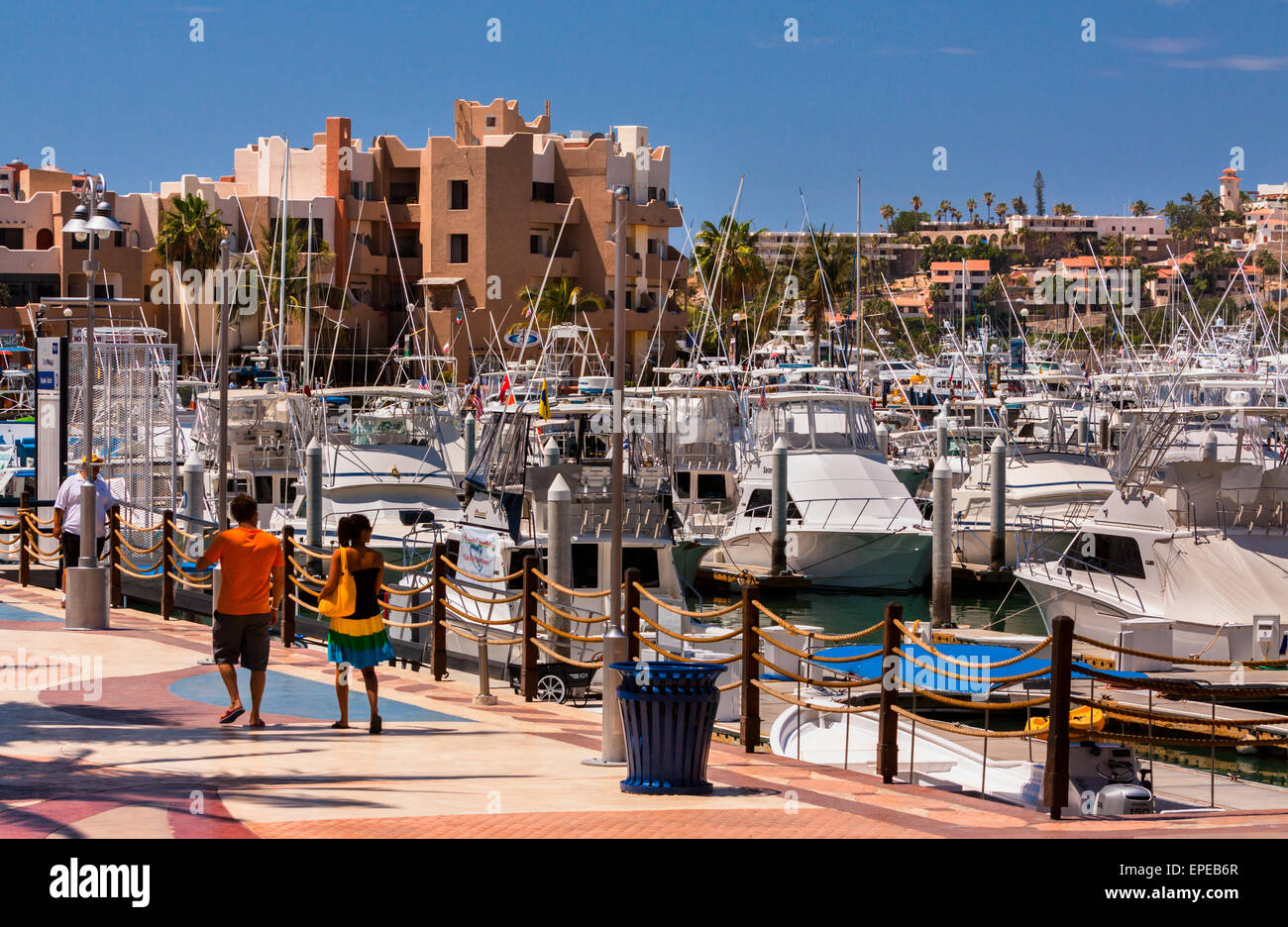 Man and Woman couple tourists walking along Cabo Marina, Cabo San Lucas ...