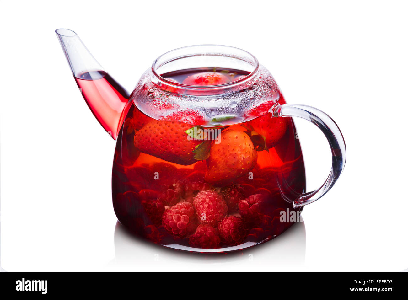 Teapot full of tea with strawberry and raspberry. Sun tea. Healthy ...