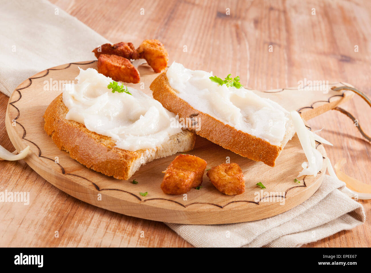 Bread with lard and scratchings on wooden kitchen board on wooden ...