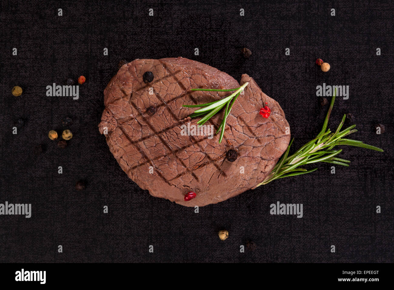 Luxurious rare tenderloin steak with herbs and peppercorn on lava rock ...
