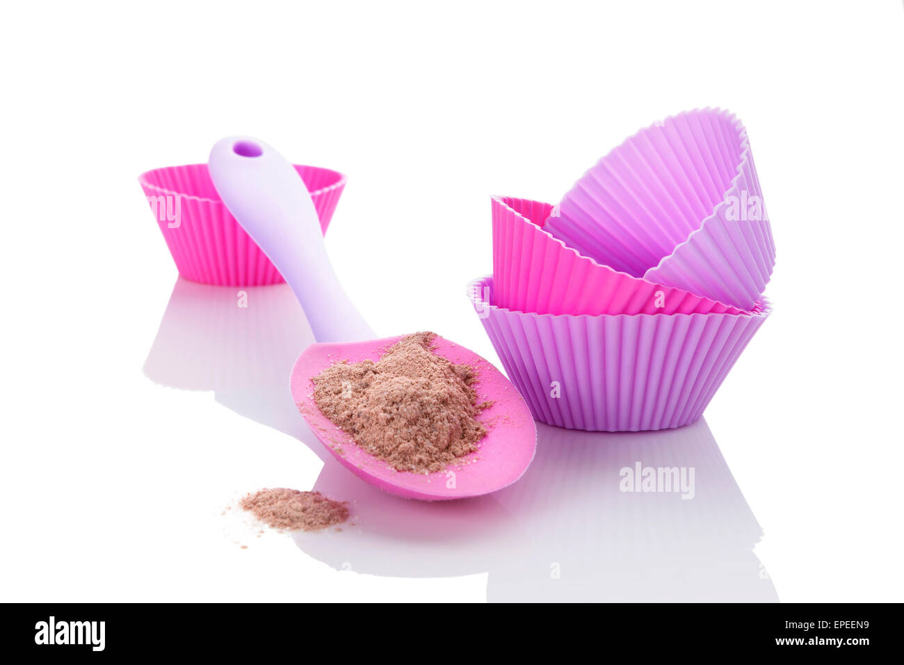 Pink and purple baking forms and baking cookie mix on spoon isolated on ...