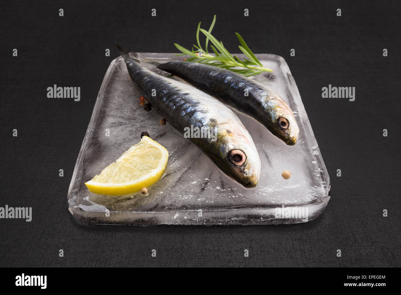Mediterranean seafood concept. Fresh anchovy fish on ice plate with ...