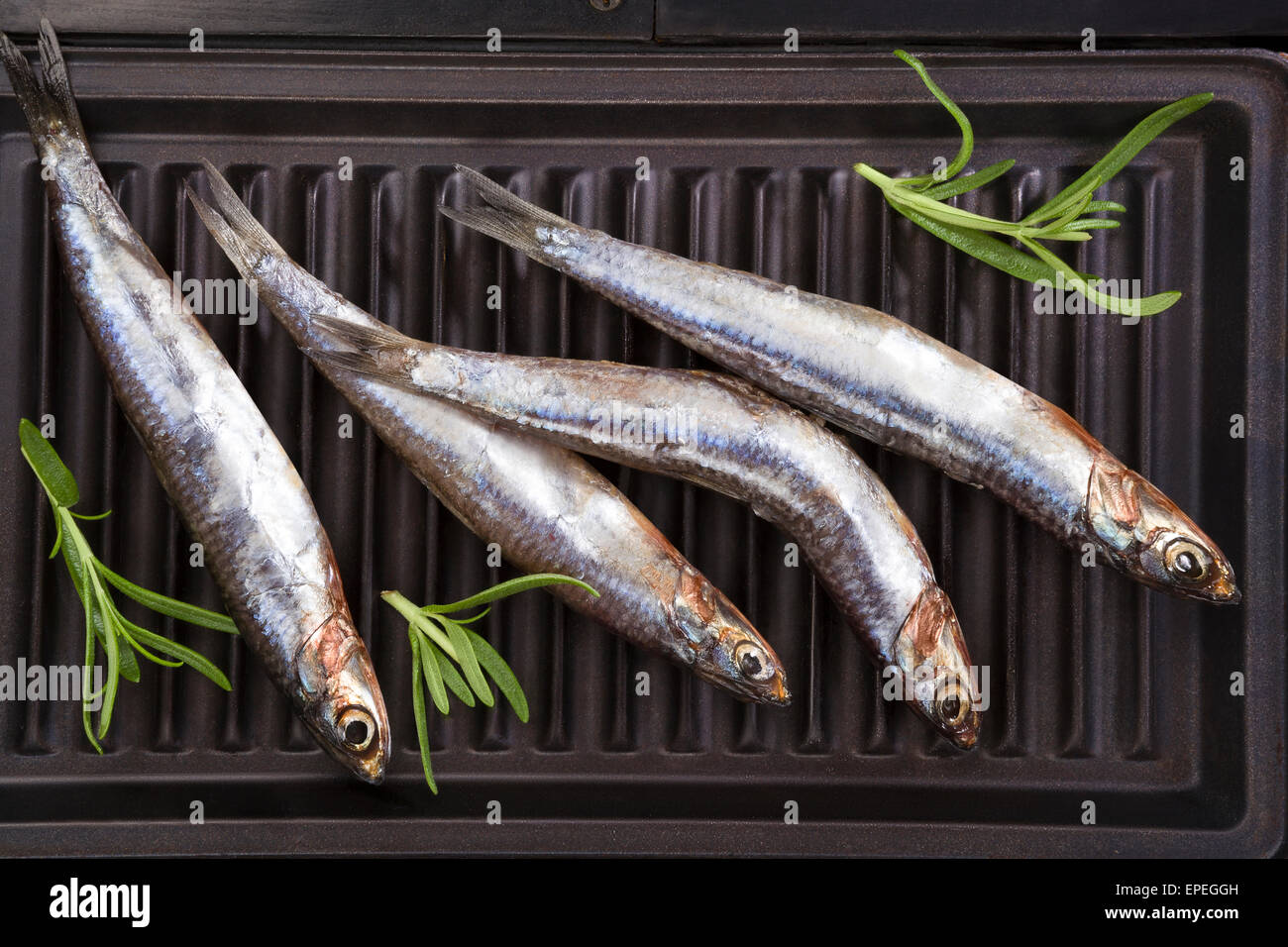 Fresh anchovy fish with fresh herbs on grill. Culinary seafood eating ...