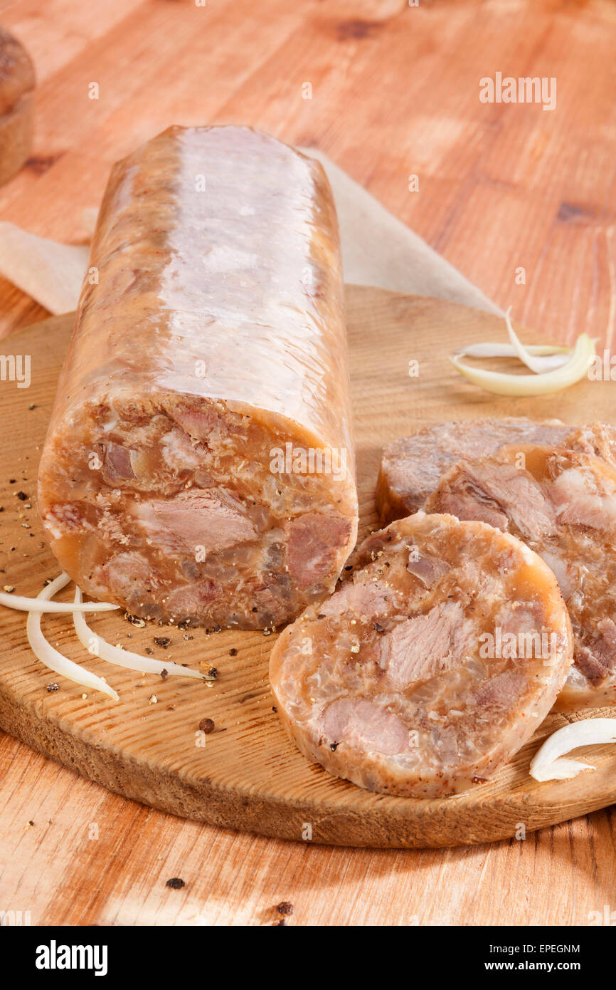 Head cheese on brown vintage cutting board with onion. Traditional ...