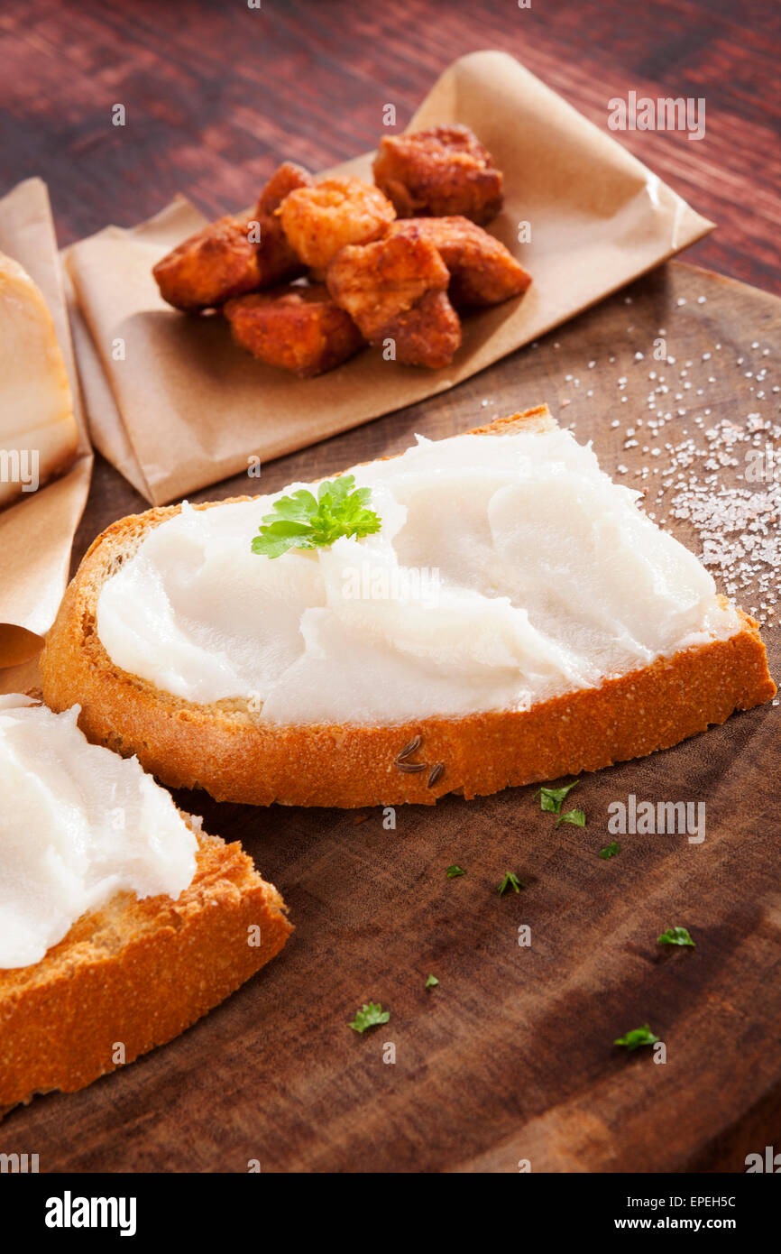 Bread with lard and pork scratchings on brown wooden background ...