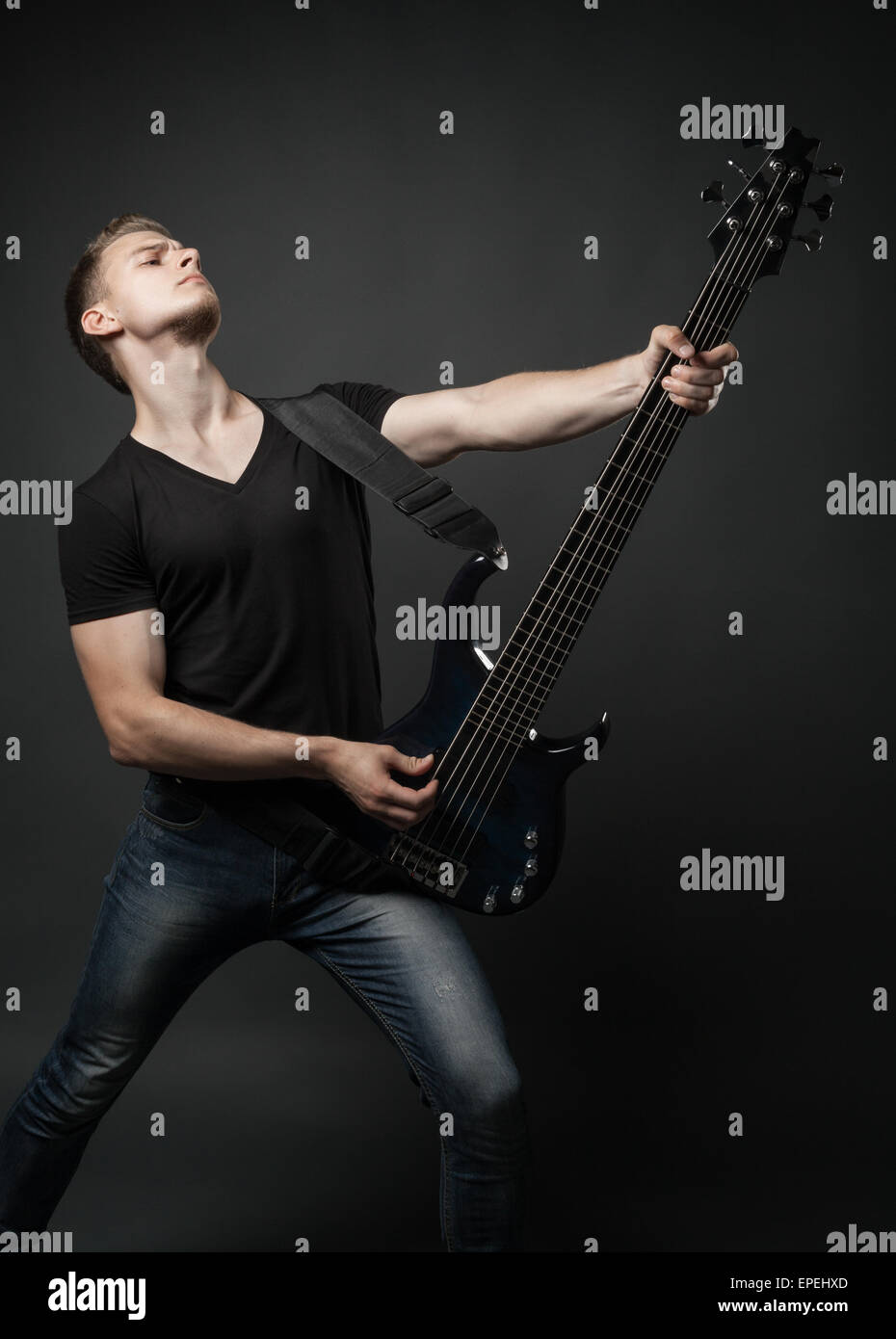 male musician playing a six-string bass guitar Stock Photo - Alamy