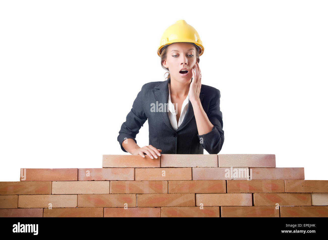 Young female builder near brick wall Stock Photo - Alamy