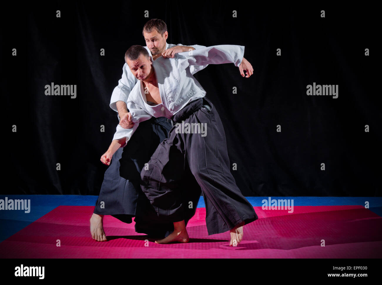 Fight between two aikido fighters on black Stock Photo - Alamy