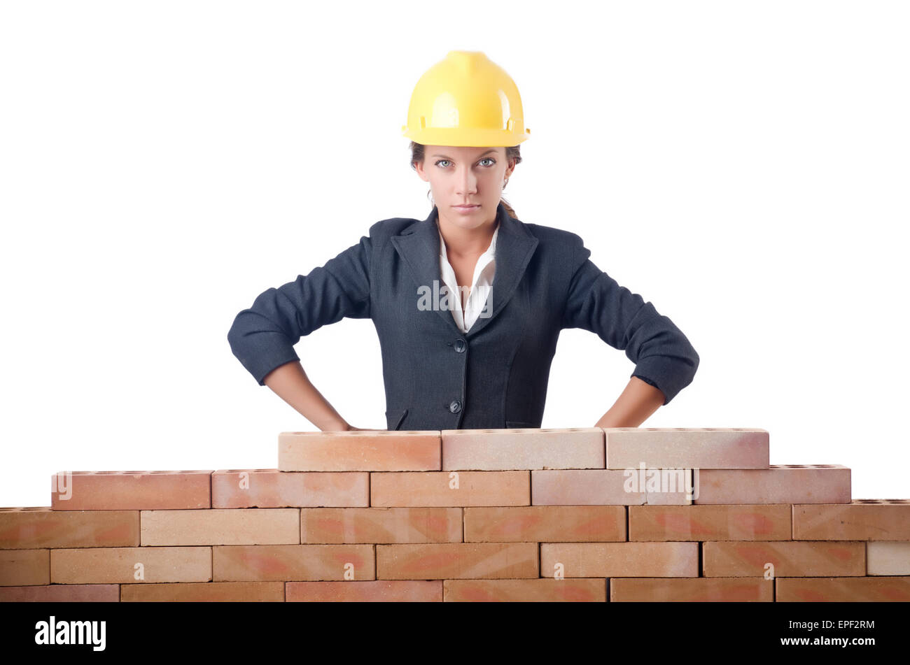 Young female builder near brick wall Stock Photo - Alamy