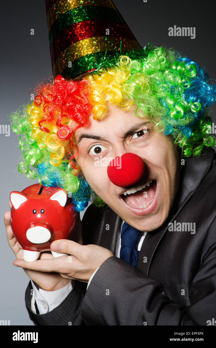 Clown with piggybank in funny concept Stock Photo - Alamy