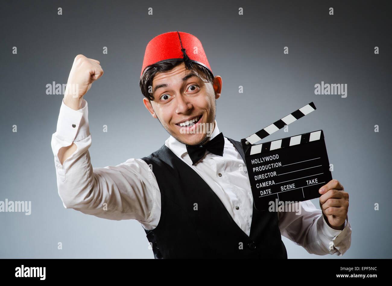 Man with movie board wearing fez hat Stock Photo - Alamy