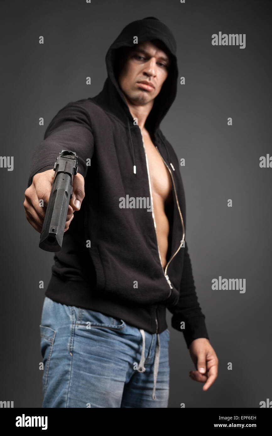 man shooting gun isolated on gray background Stock Photo - Alamy