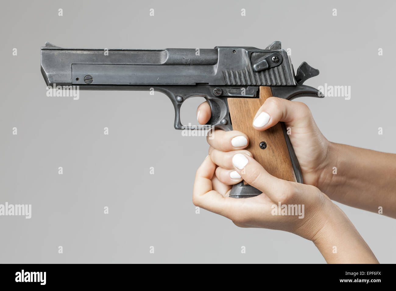 female hands with gun isolated on gray background Stock Photo - Alamy