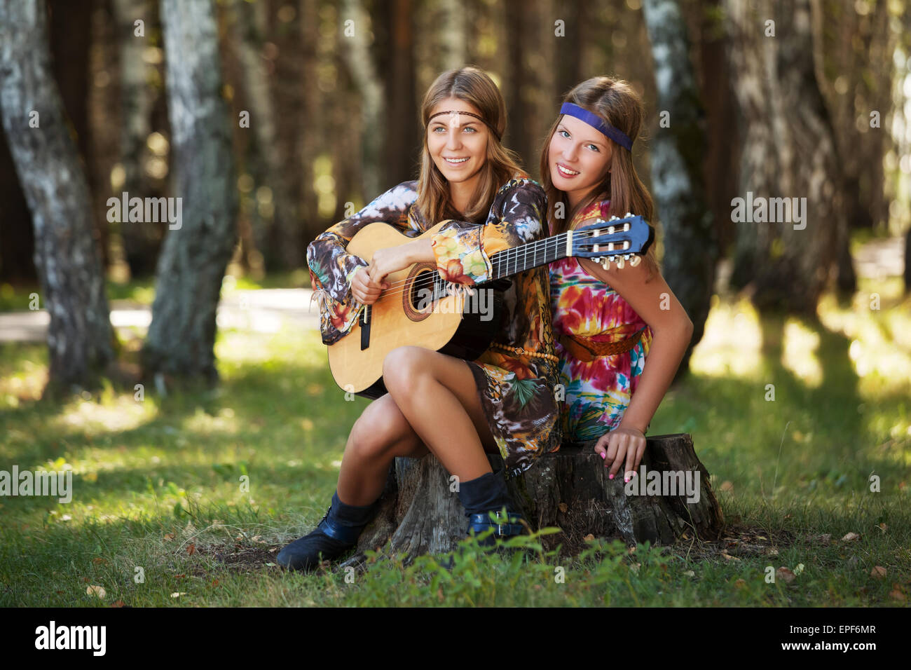 Two hippie girls with guitar in a summer forest Stock Photo - Alamy