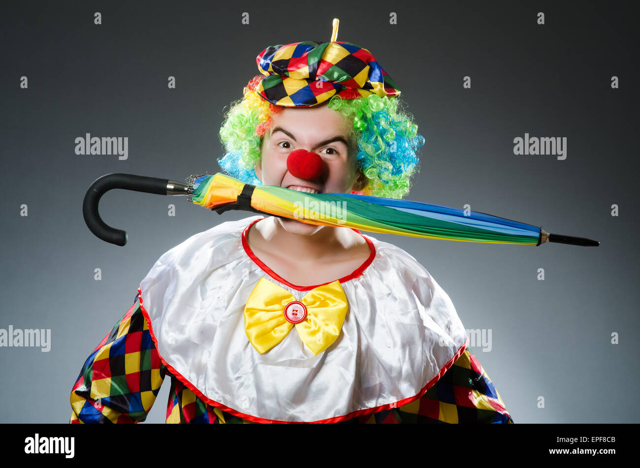 Funny clown with colourful umbrella Stock Photo - Alamy