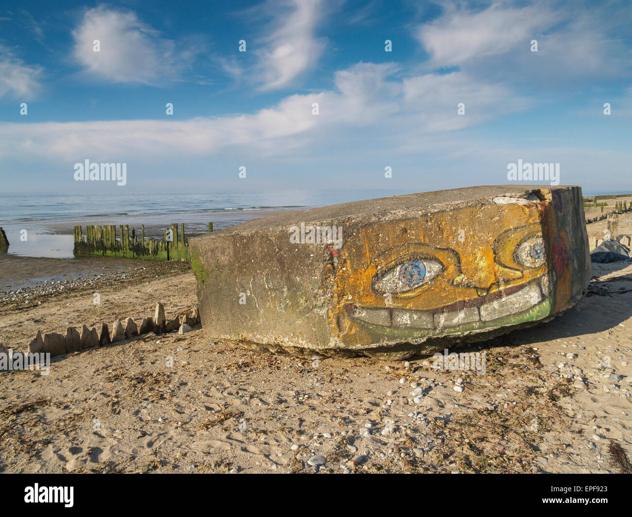 German ww2 d-day concrete beach defences painted with a graffiti face ...