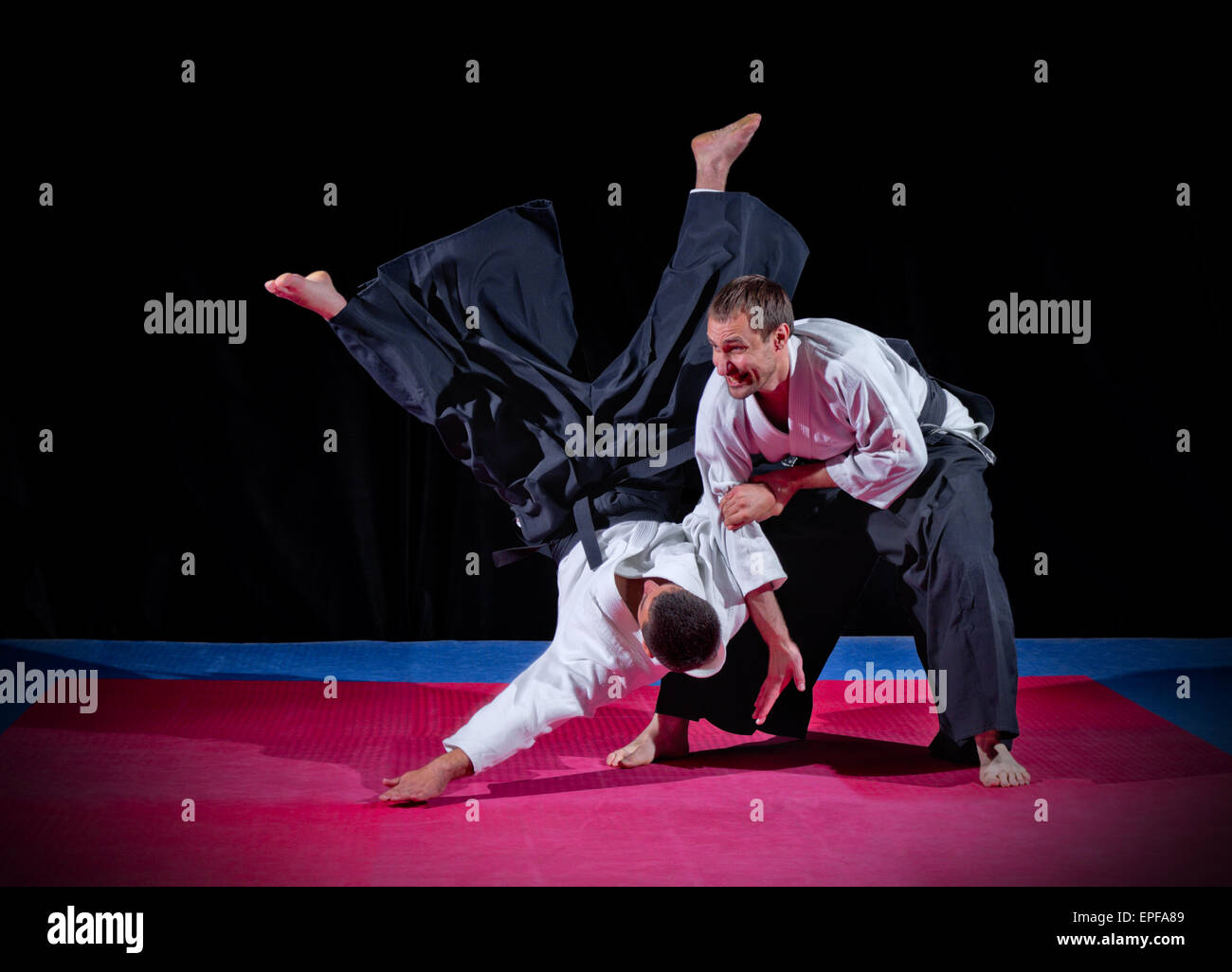 Fight between two aikido fighters on black Stock Photo - Alamy