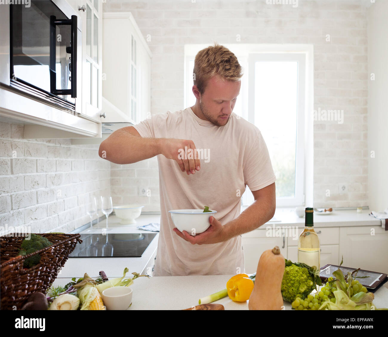 Man cooking at home preparing salad in kitchen Stock Photo - Alamy
