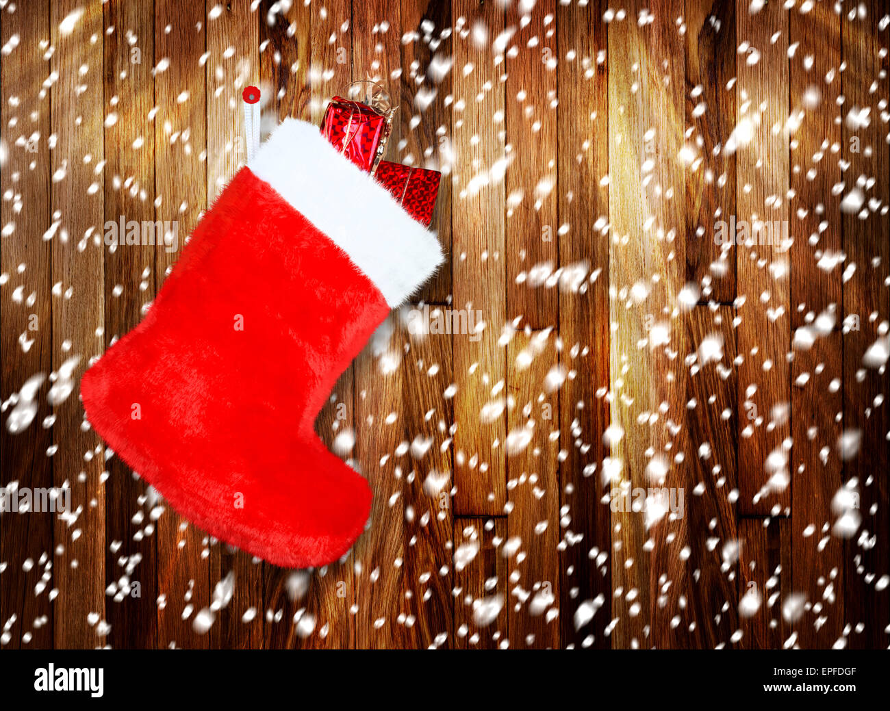 Red christmas boot with gifts on background wooden wall Stock Photo - Alamy