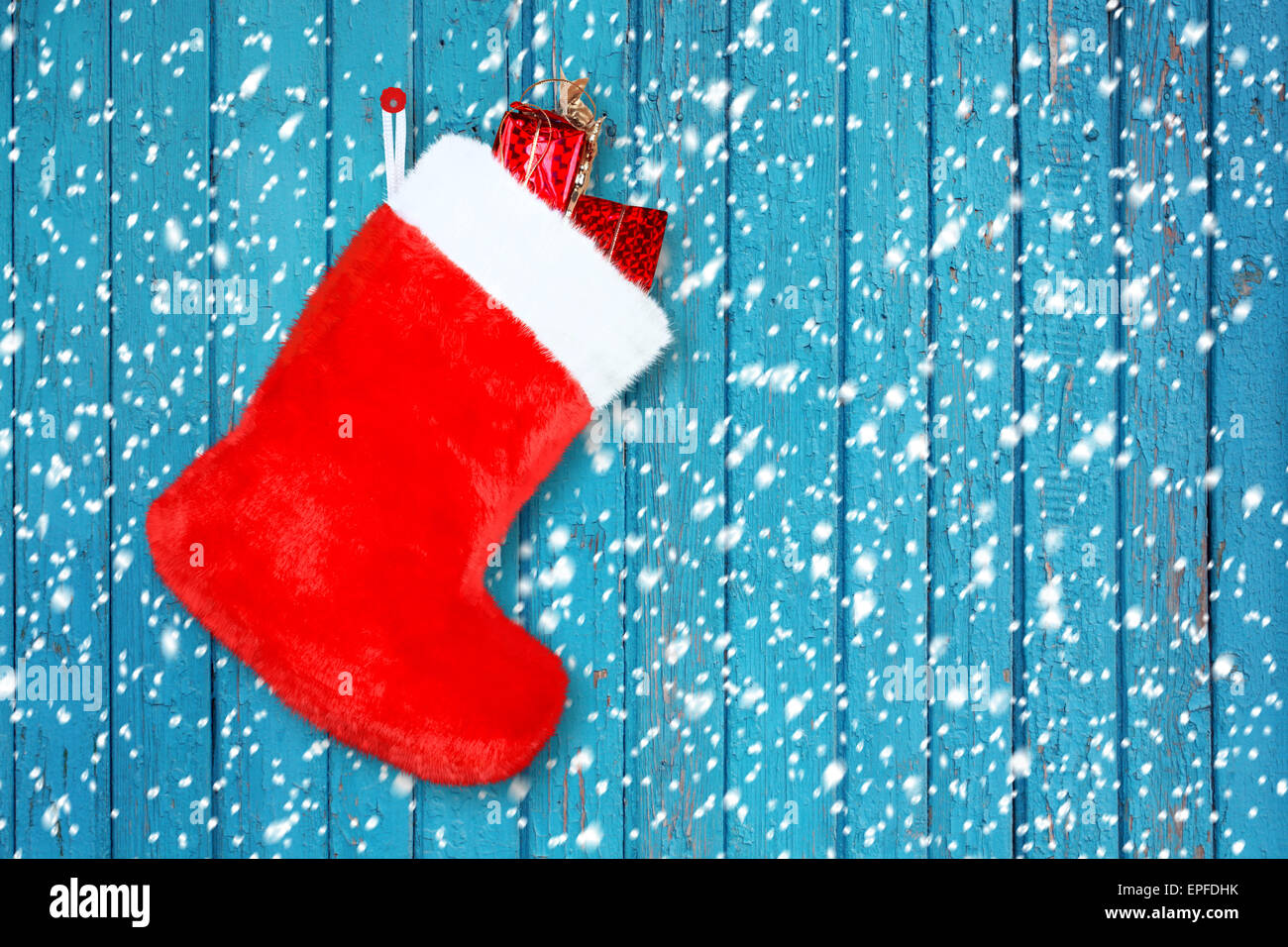 Red christmas boot with gifts on background wooden wall Stock Photo - Alamy