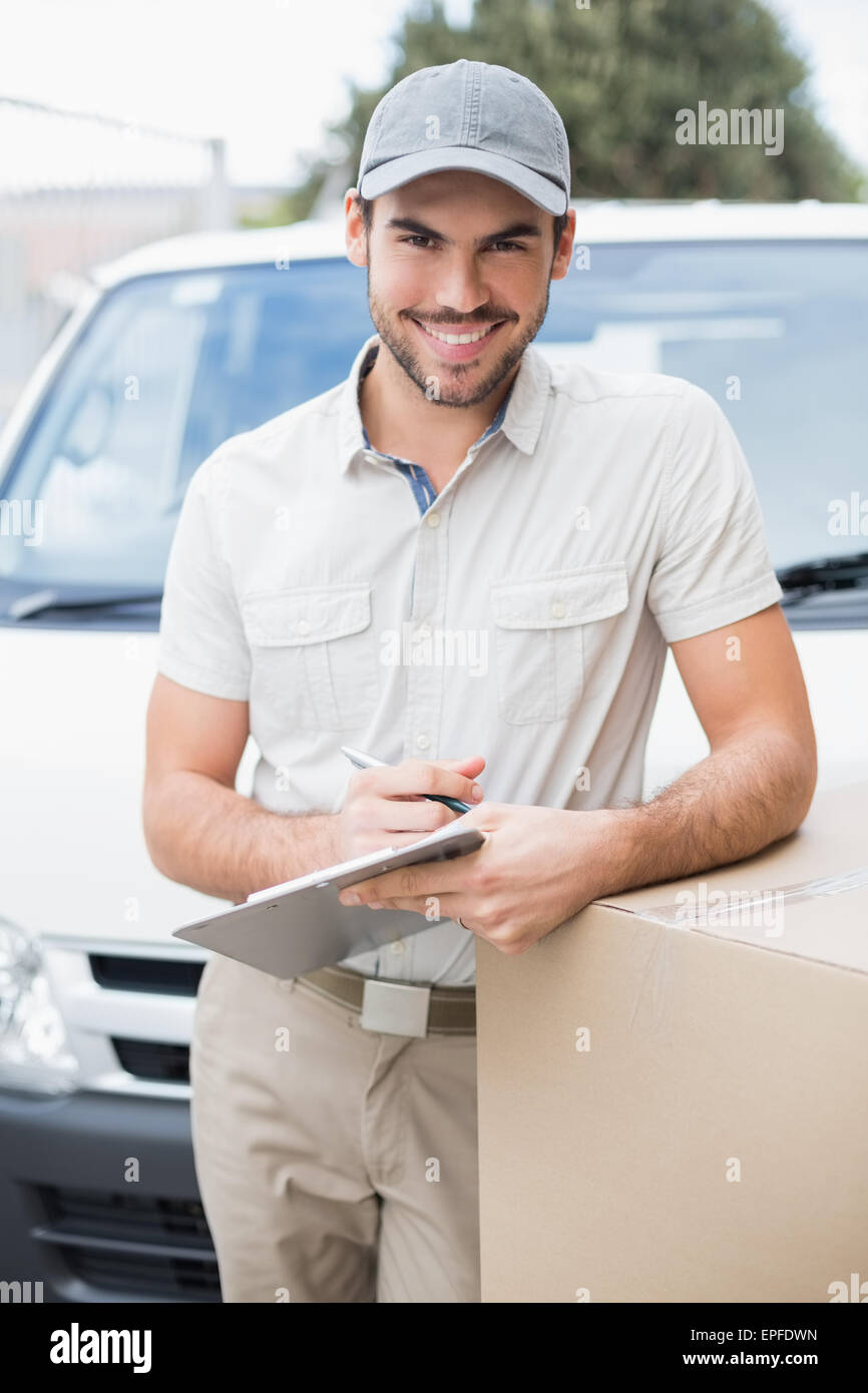 Delivery driver smiling at camera by his van Stock Photo - Alamy
