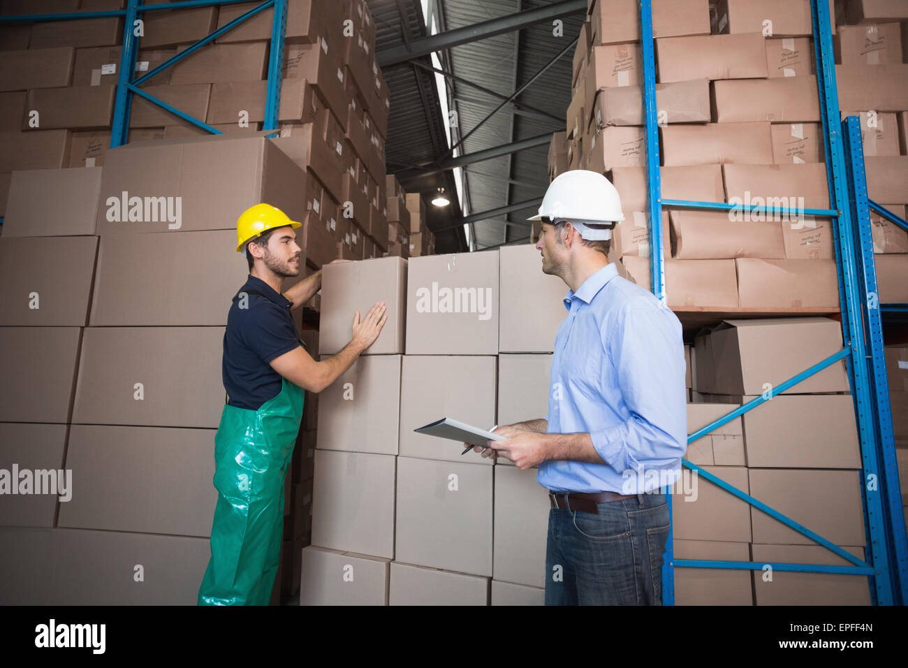 Warehouse worker loading up a pallet with manager Stock Photo - Alamy