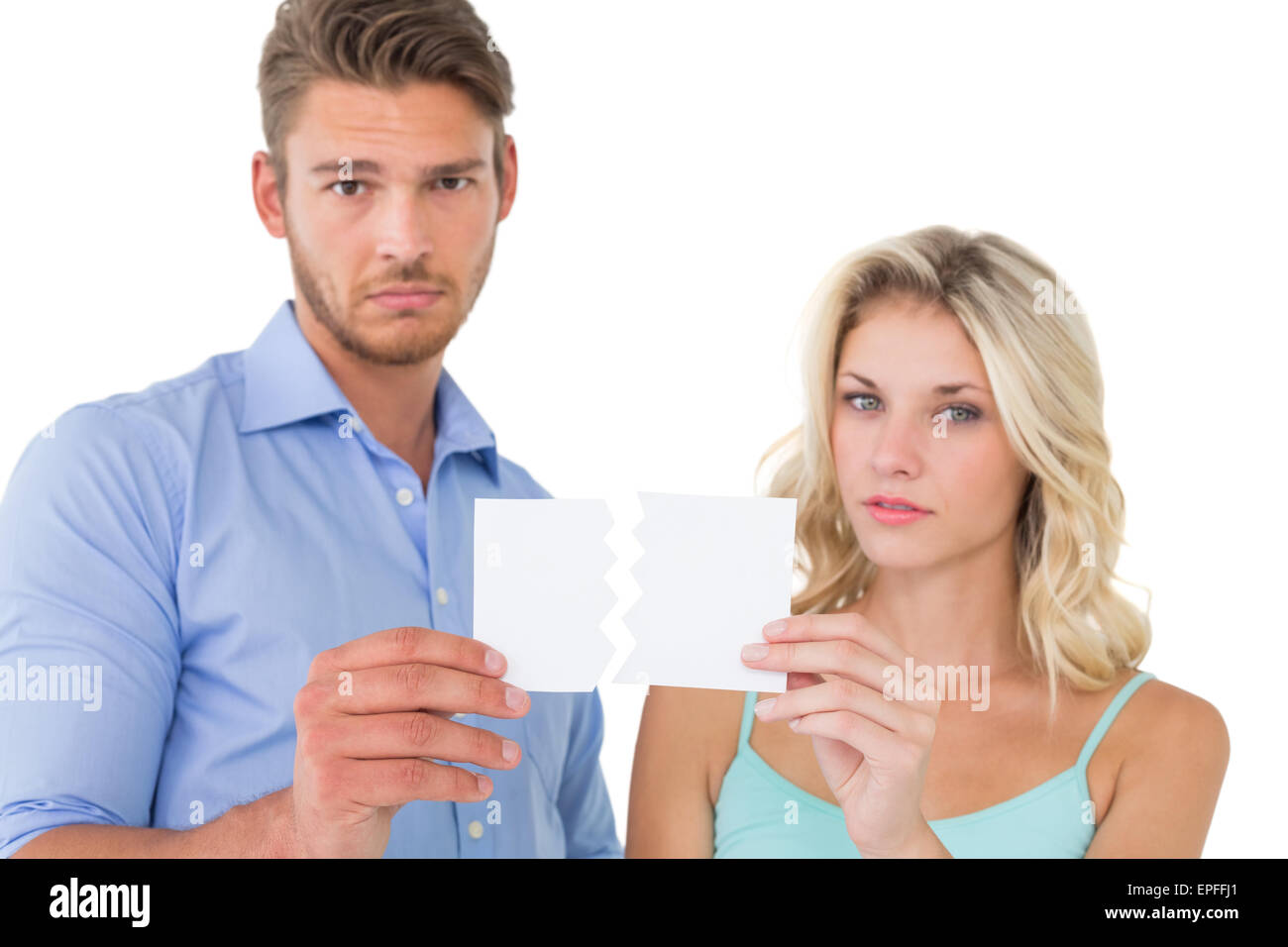 Upset couple holding torn piece of paper Stock Photo - Alamy