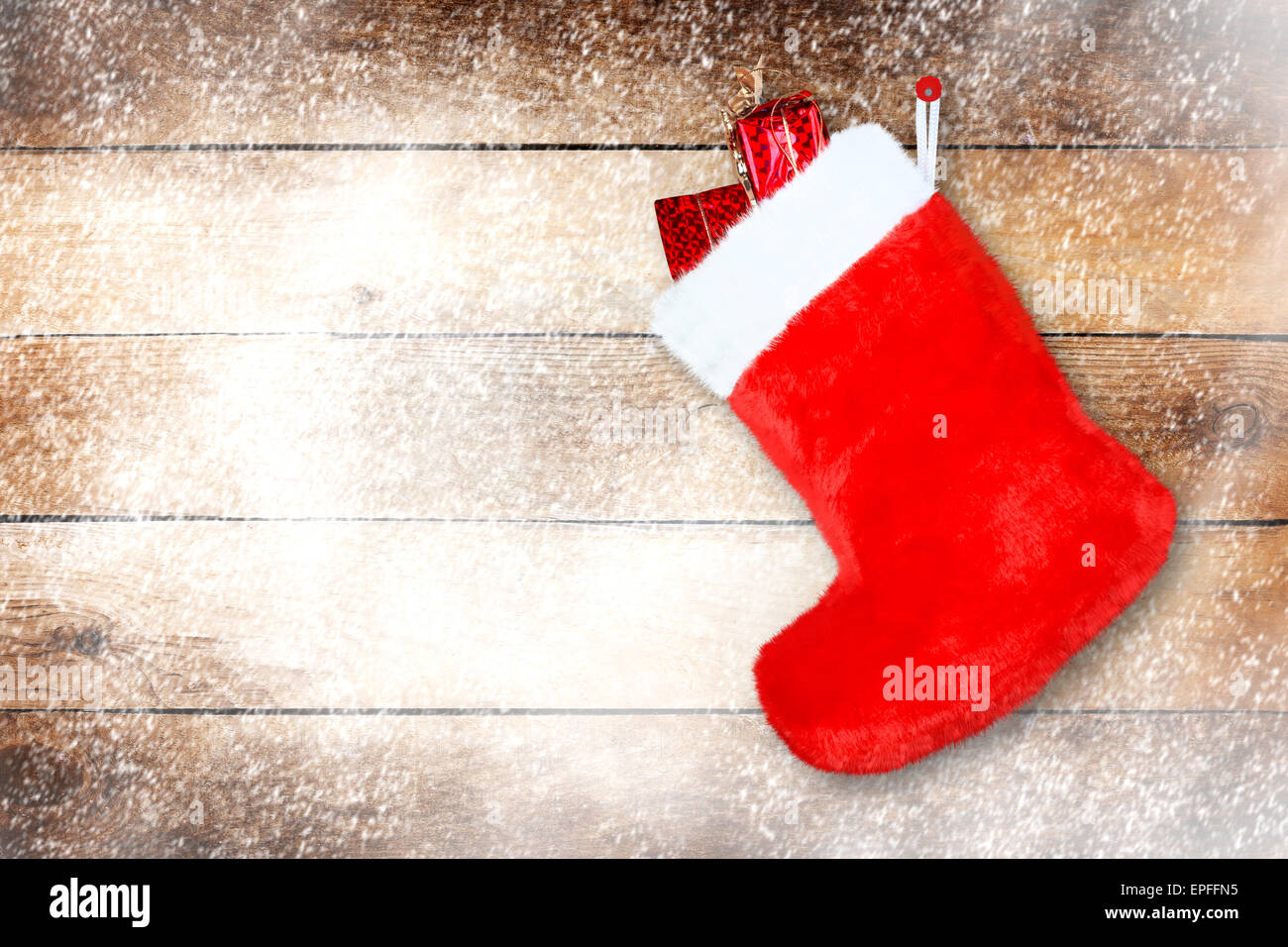 Red christmas boot with gifts on background wooden wall Stock Photo - Alamy