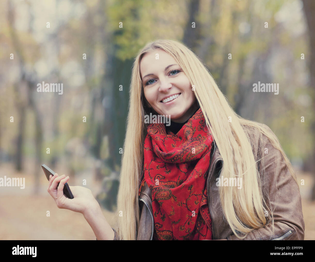 Portrait of a smiling beautiful woman texting sms Stock Photo - Alamy