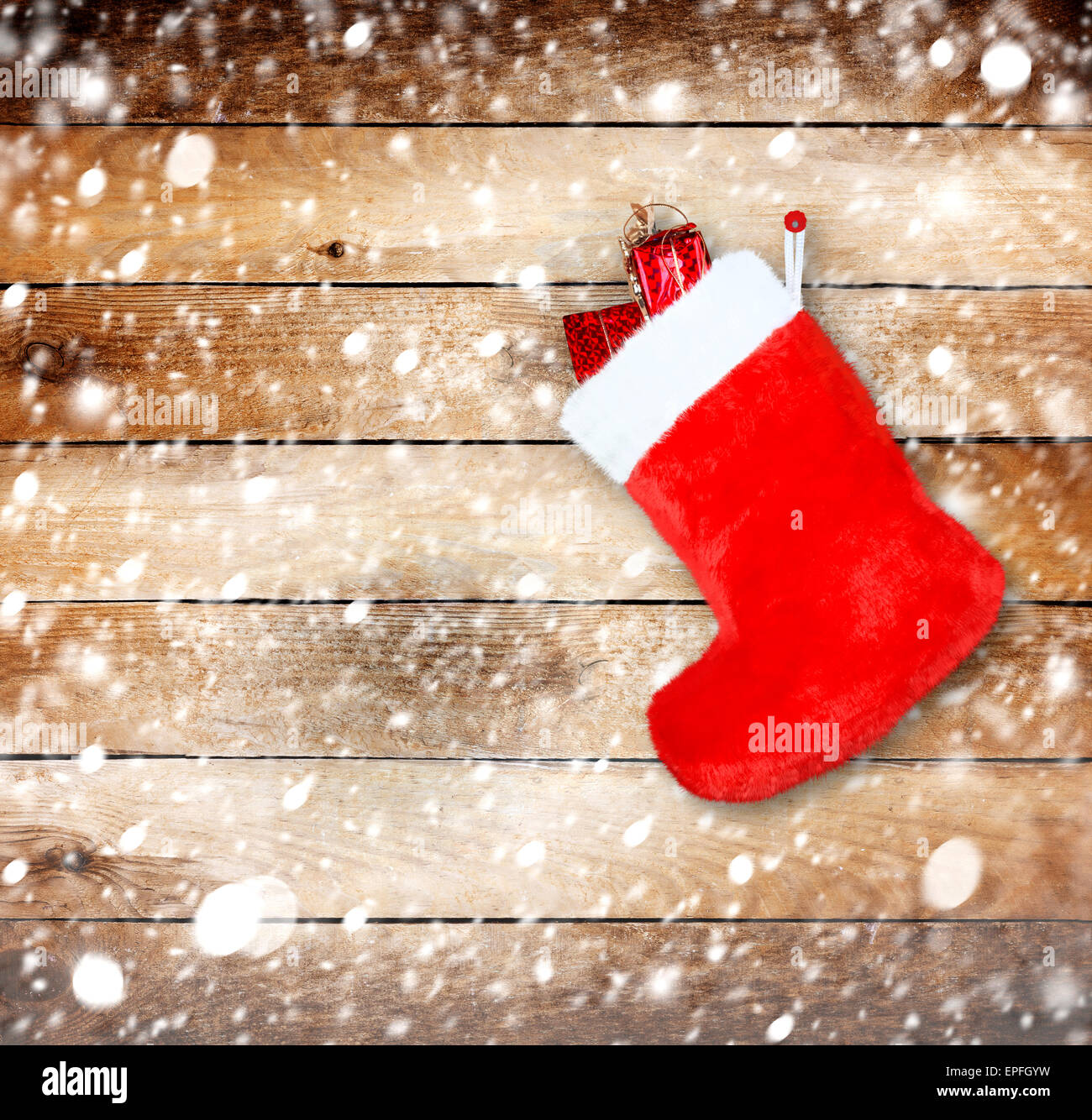 Red christmas boot with gifts on background wooden wall Stock Photo - Alamy